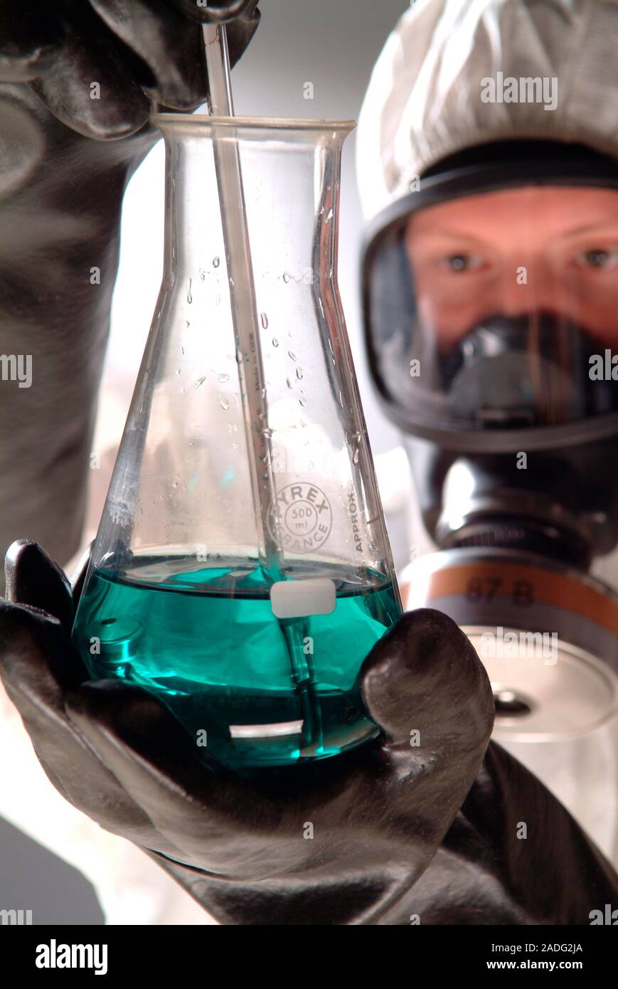 Handling toxic material. Man wearing a protective suit, breathing ...