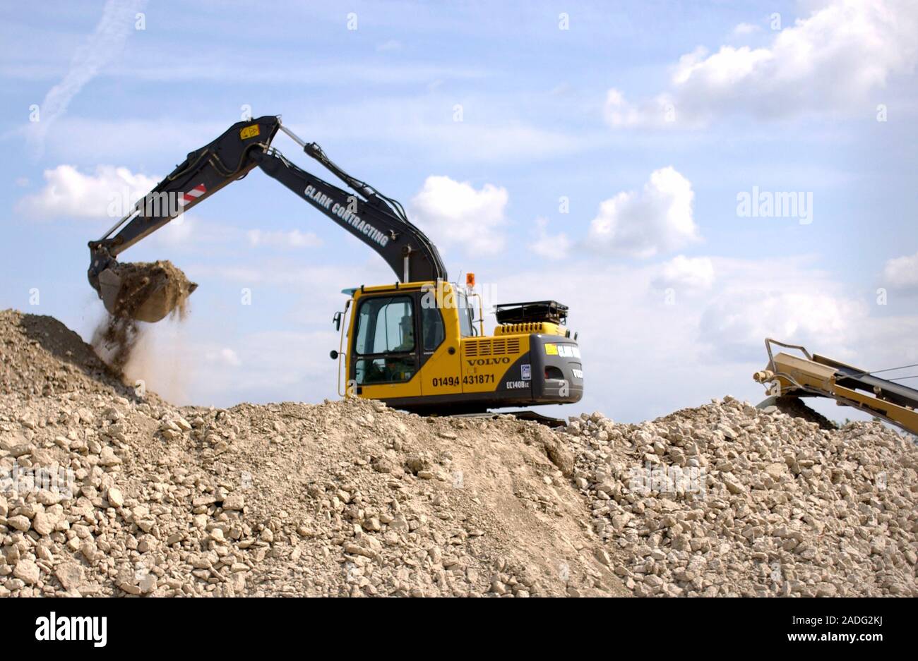 Land decontamination. Digger clearing rubble from a former industrial ...