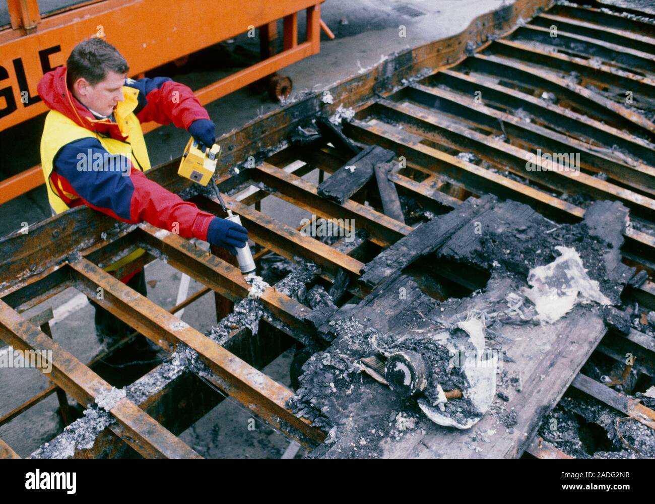 MODEL RELEASED. Radiation monitoring a burnt trailer. Researcher using ...