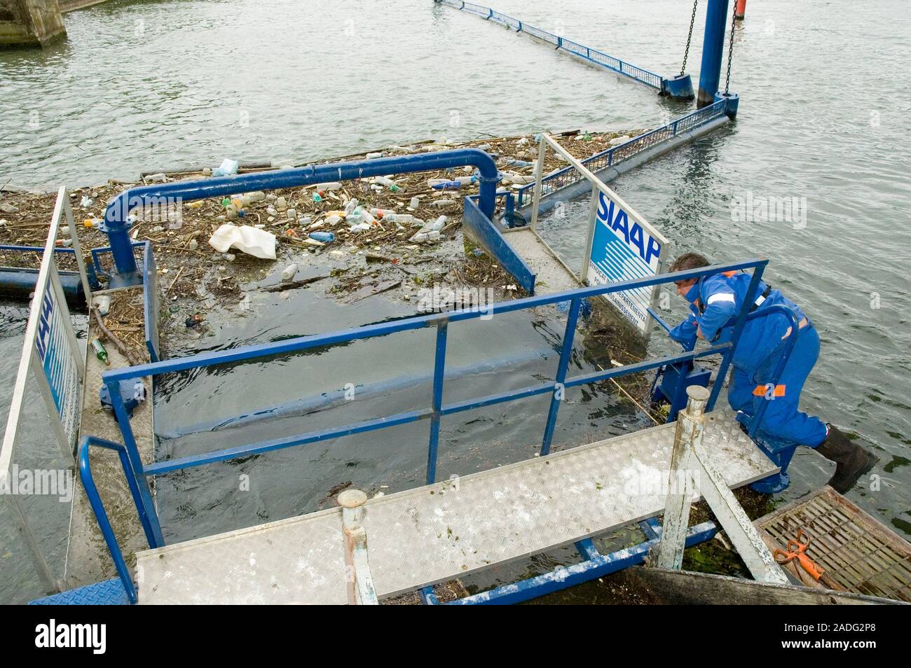 River pollution clean-up. Voluntary worker on a barge being used as ...