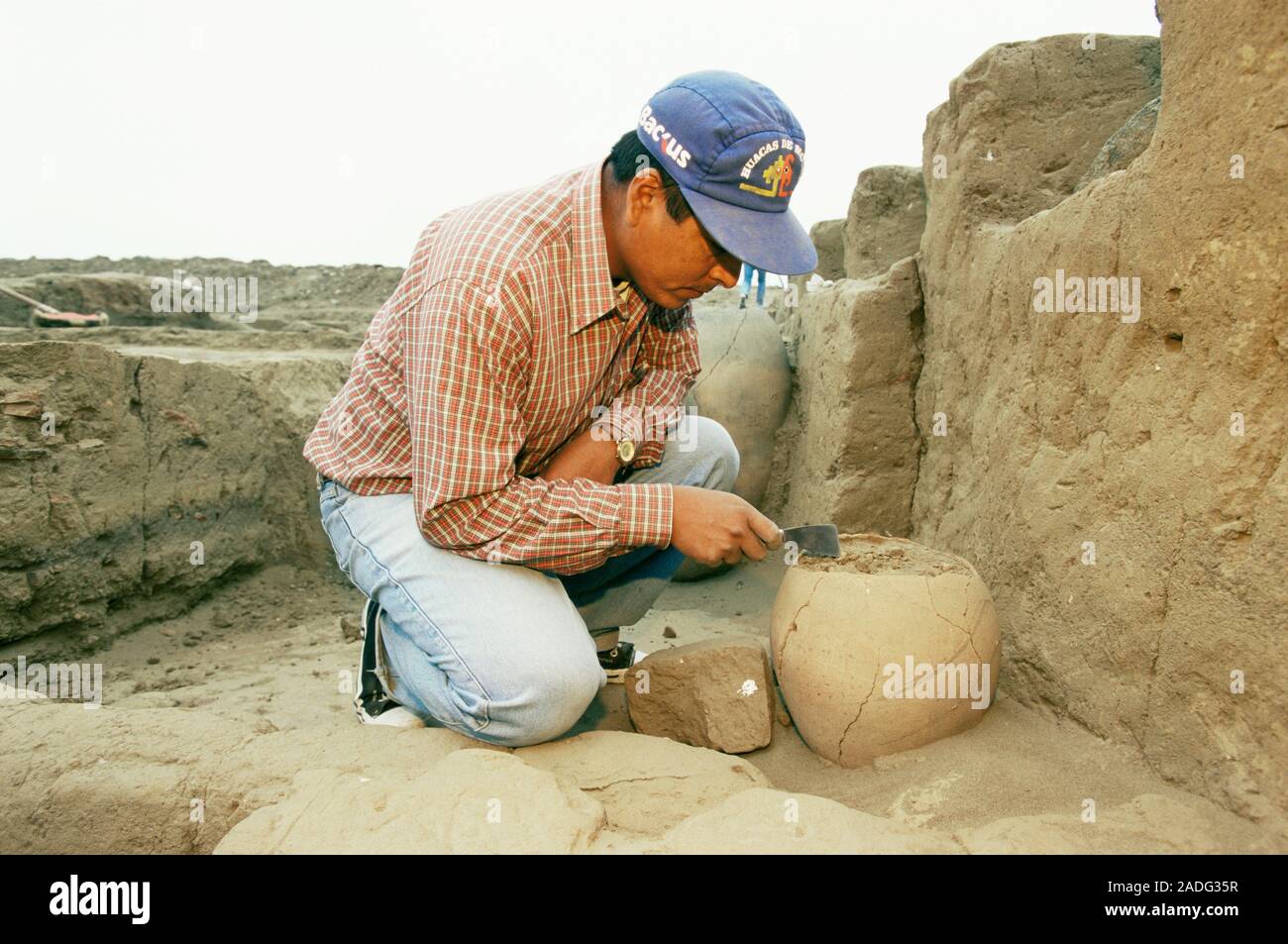Moche archaeological site. Archaeologists excavating a piece of pottery ...