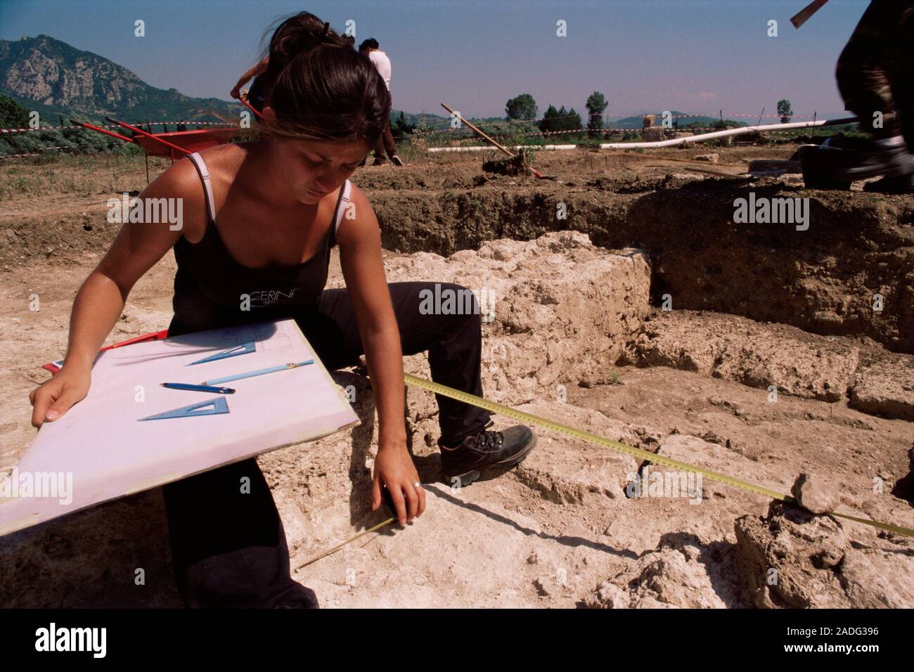 Archaeological measurements. Archaeologist using a tape measure and ...