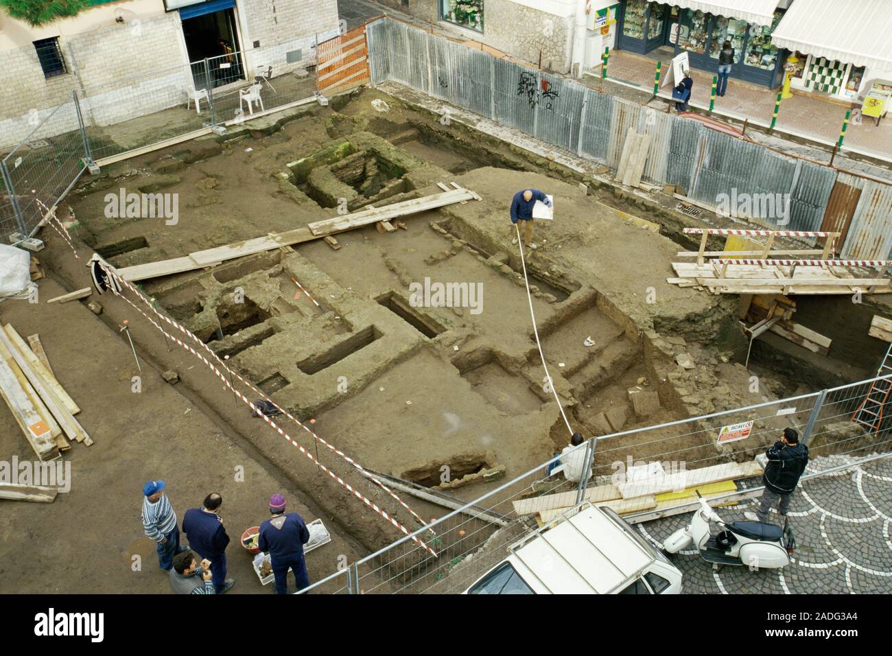 Roman archaeological site. Archaeologists making measurements at the ...