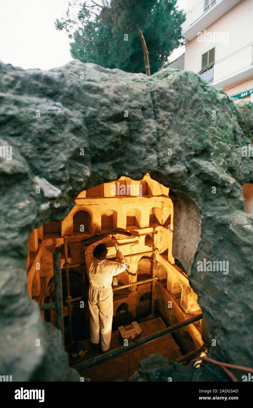 Roman burial house. Restorer working inside a Roman burial site. This ...