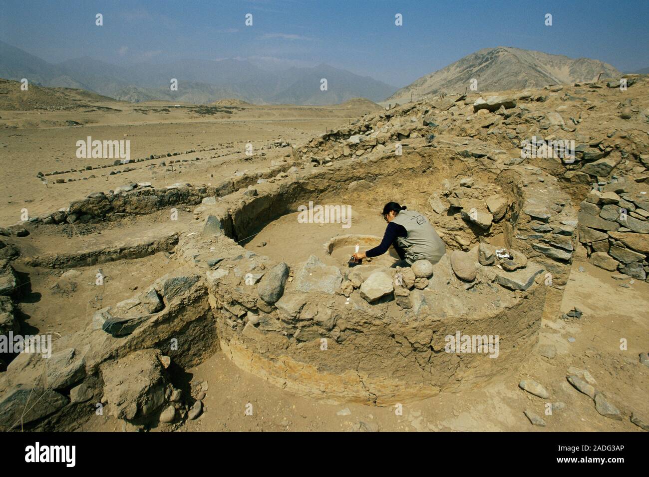Caral archaeological site. Archaeologist excavating inside a circular ...