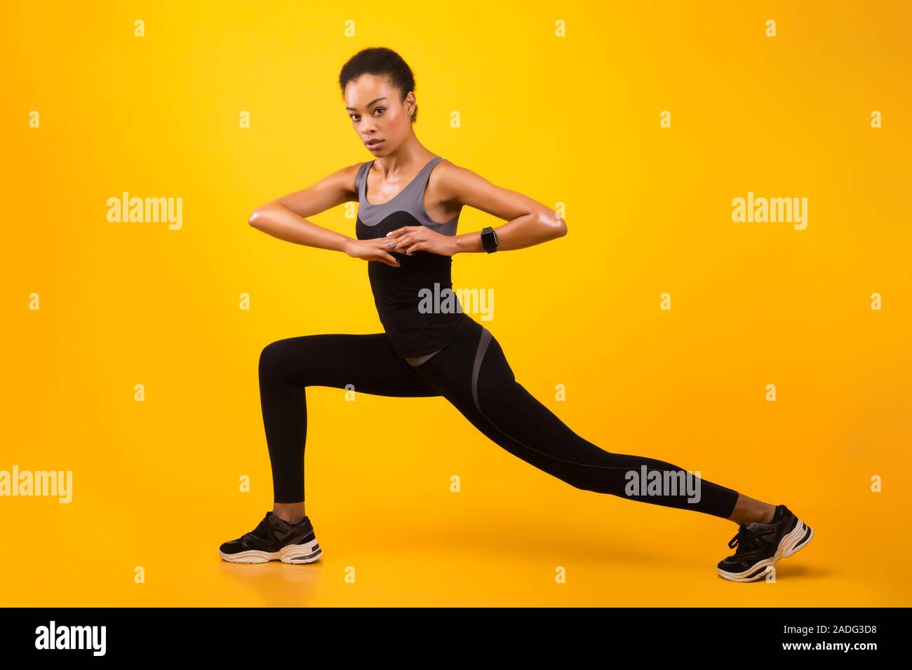 Black Girl Doing Deep Lunge Exercise Stretching Legs In Studio Stock ...