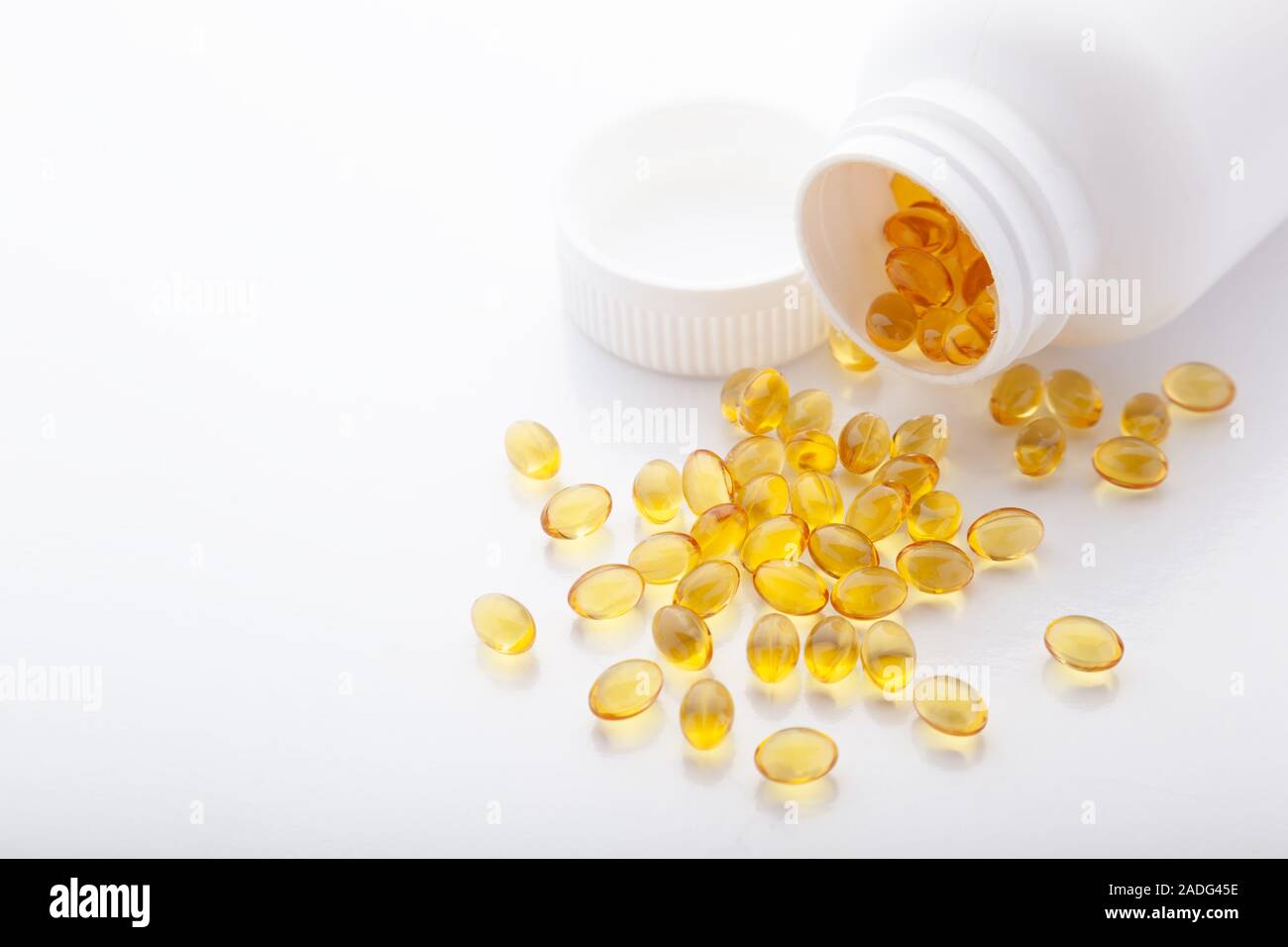 Top view of Gold fish oil scattered from pill bottle isolated for good ...