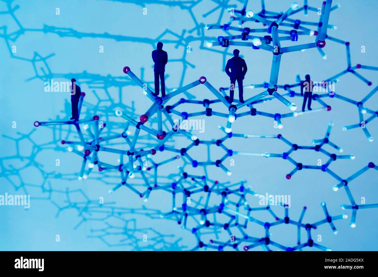Human genome, conceptual image. Human figures on a plastic molecular ...