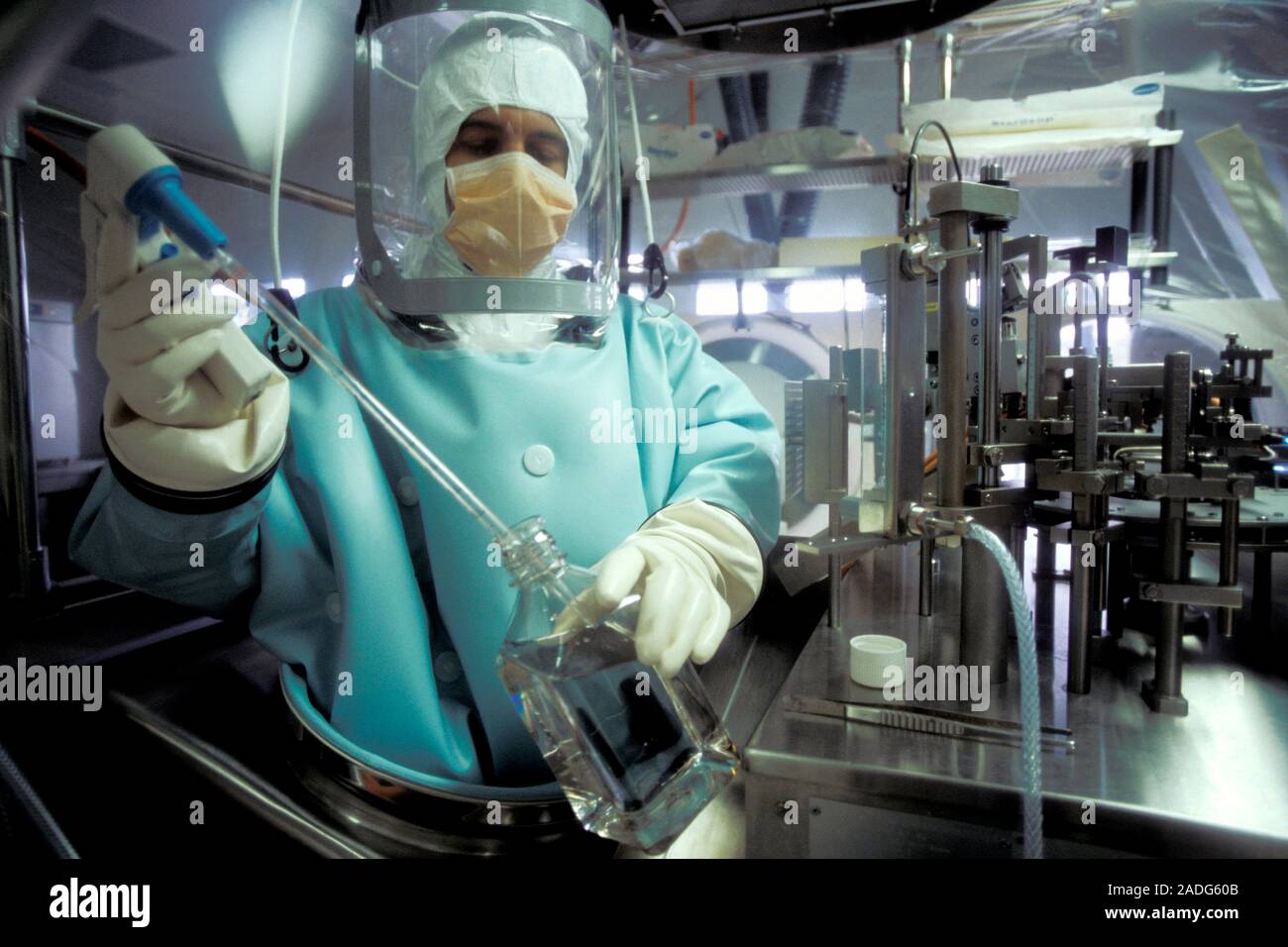 Gene therapy research. Researcher in a protective suit handling DNA ...