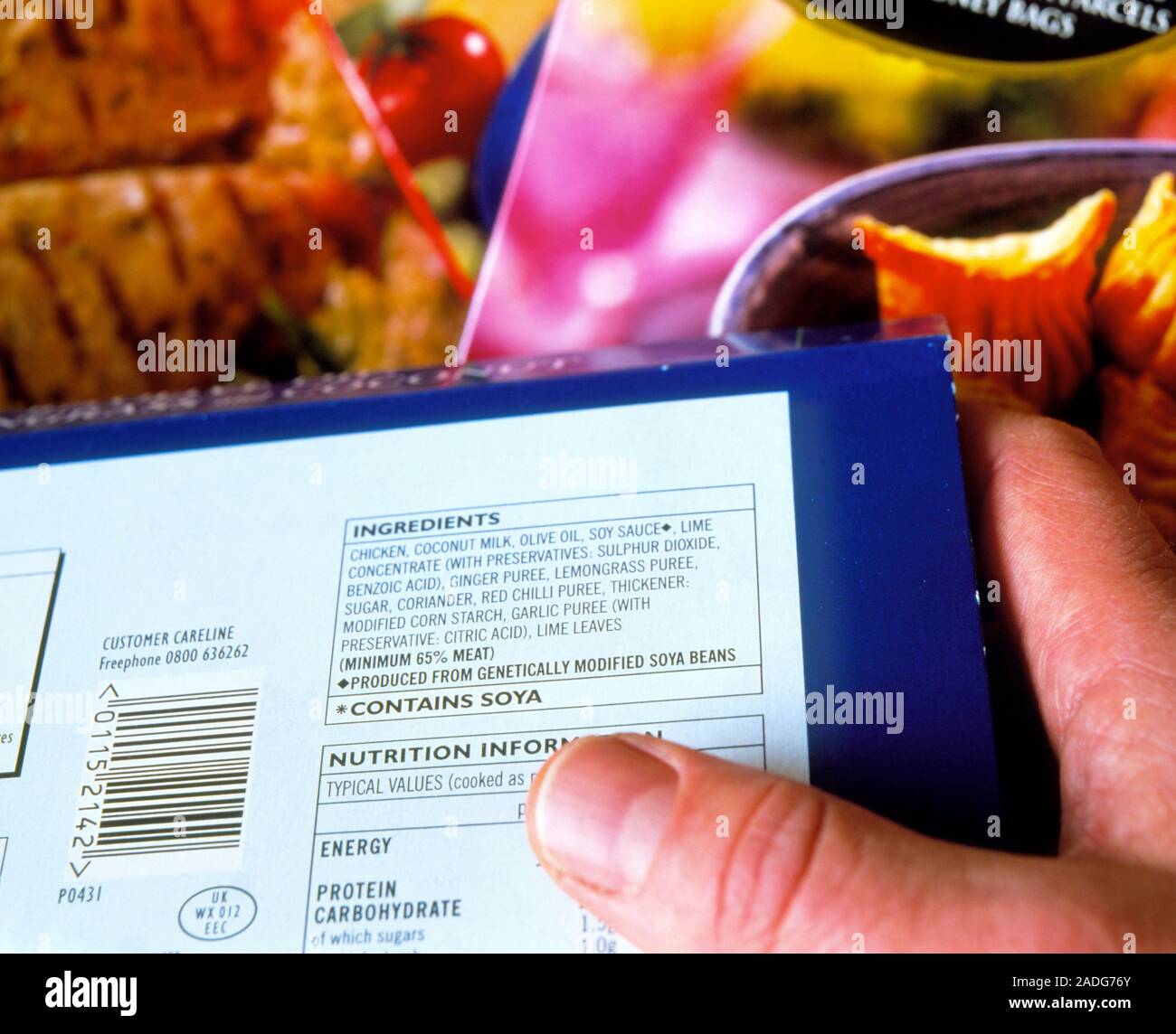 Genetically modified food ingredients. Hand holding a packaged food ...