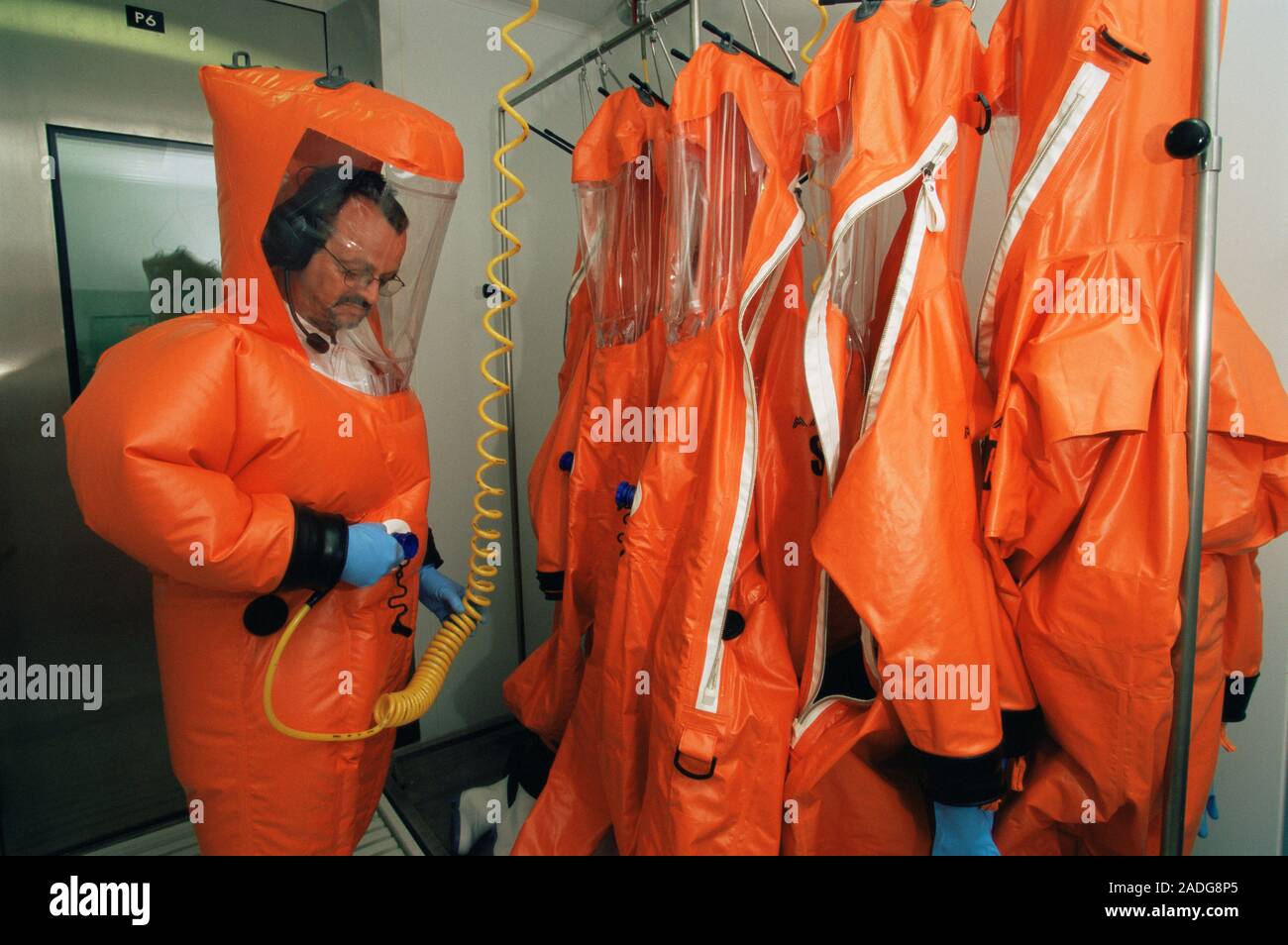 Virologist putting on a protective full body suit before entering a ...