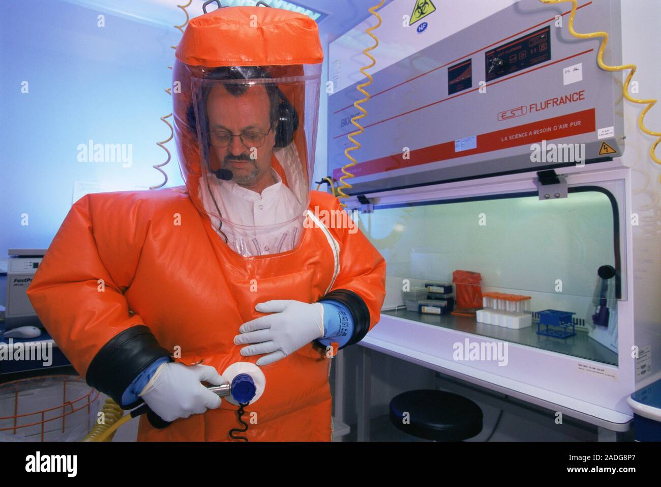 Virologist using a protective full body suit while working in a high ...