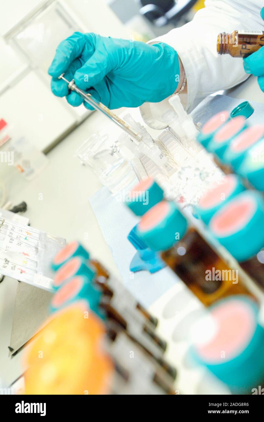 Biological research. Scientist using a syringe to measure out a ...