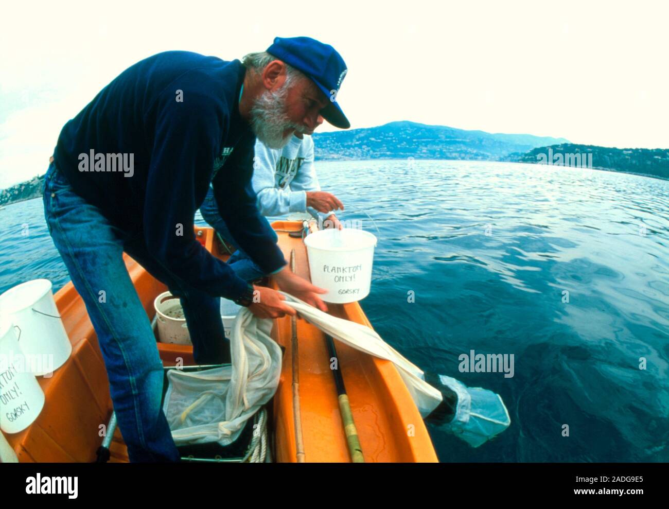 Plankton research. Biological researcher in a boat collecting samples ...