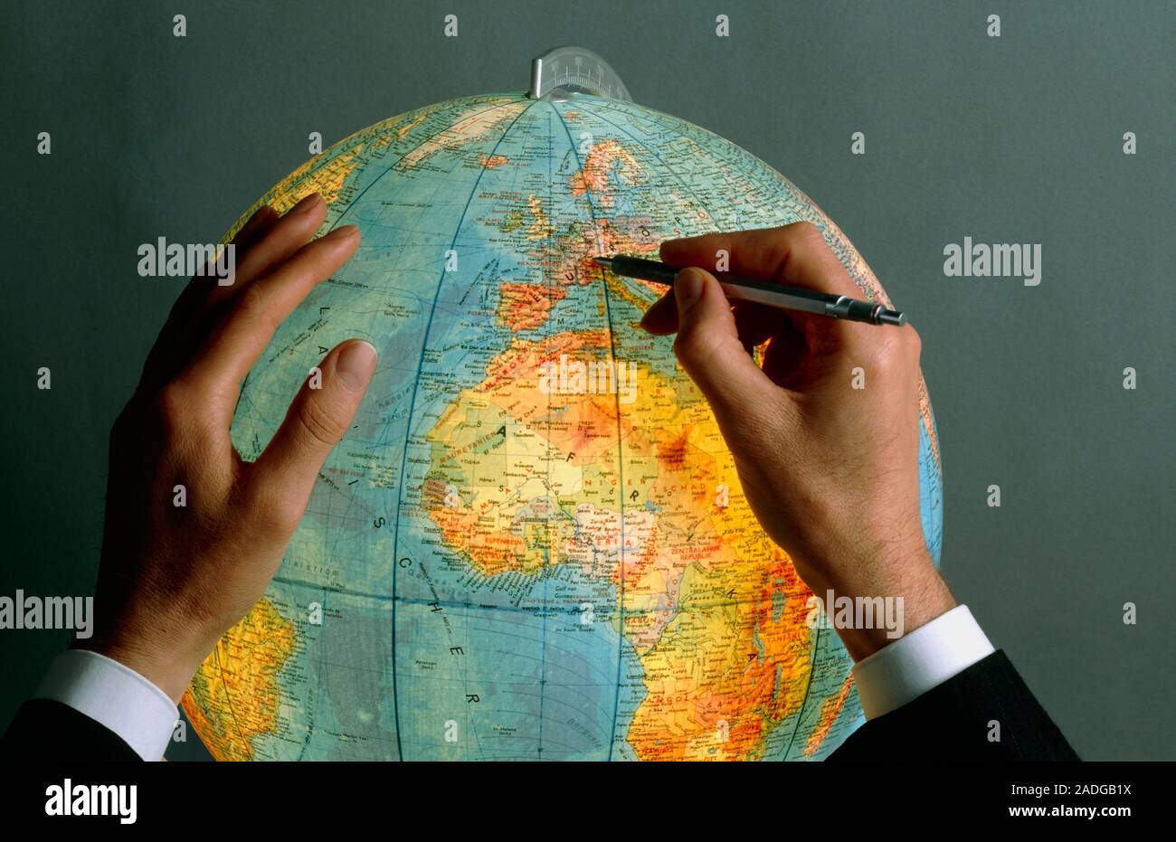 Globe. Man pointing to a place within Europe on a globe representing ...