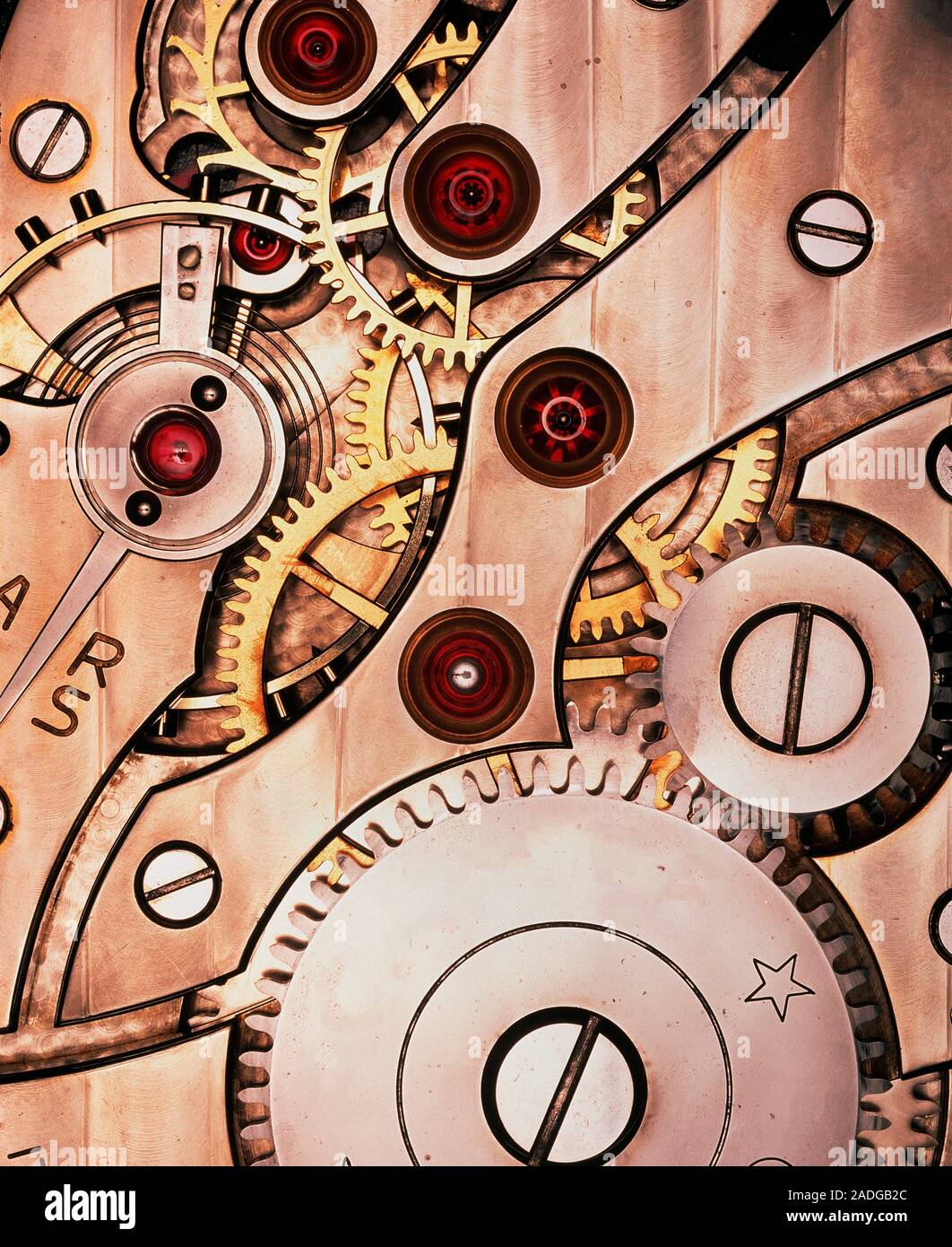 Watch cogs. Internal cogs and gears of a watch escapement. The red ...