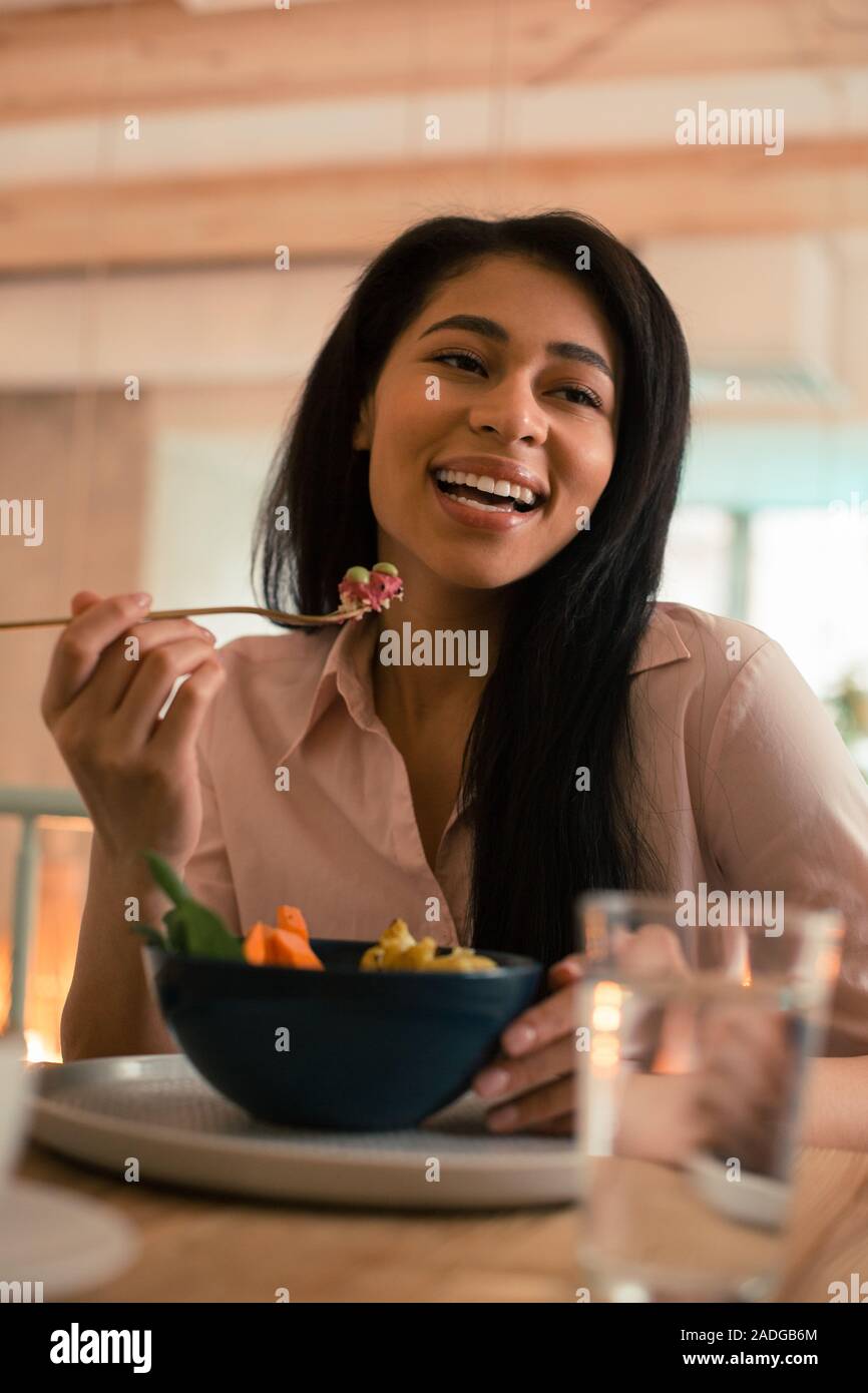 Delighted woman laughing while holding food on her fork Stock Photo - Alamy