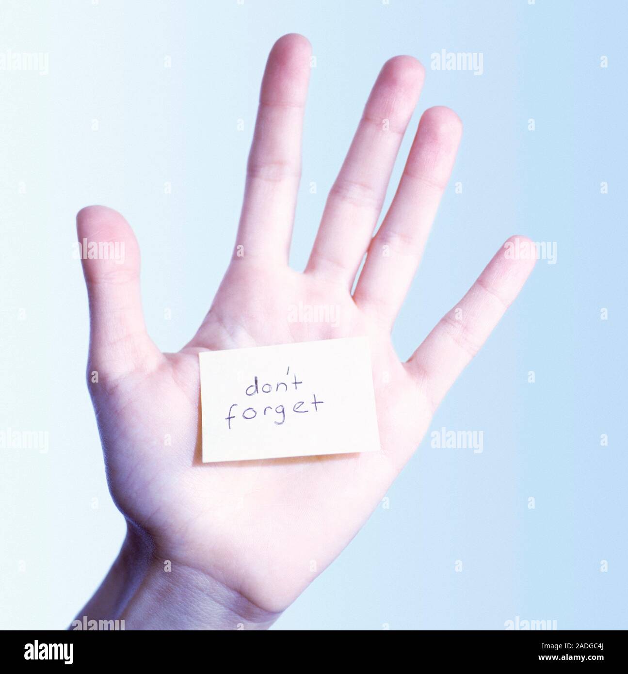 Forgetfulness, conceptual image. Post-it note stuck to a hand as a ...
