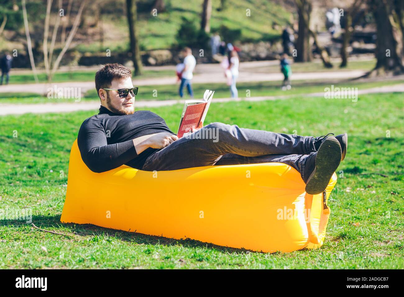 book reading concept. man in city park on inflatable mattress Stock ...