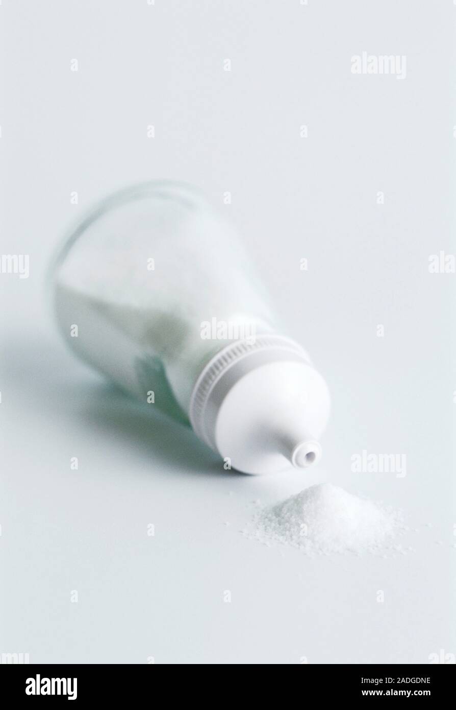 Salt. Pile of table salt being poured from a salt- cellar. Table salt ...