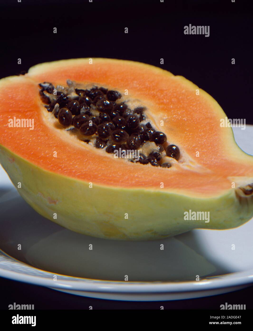Papaya fruit (Carica papaya). Sliced, ripe papaya revealing numerous ...