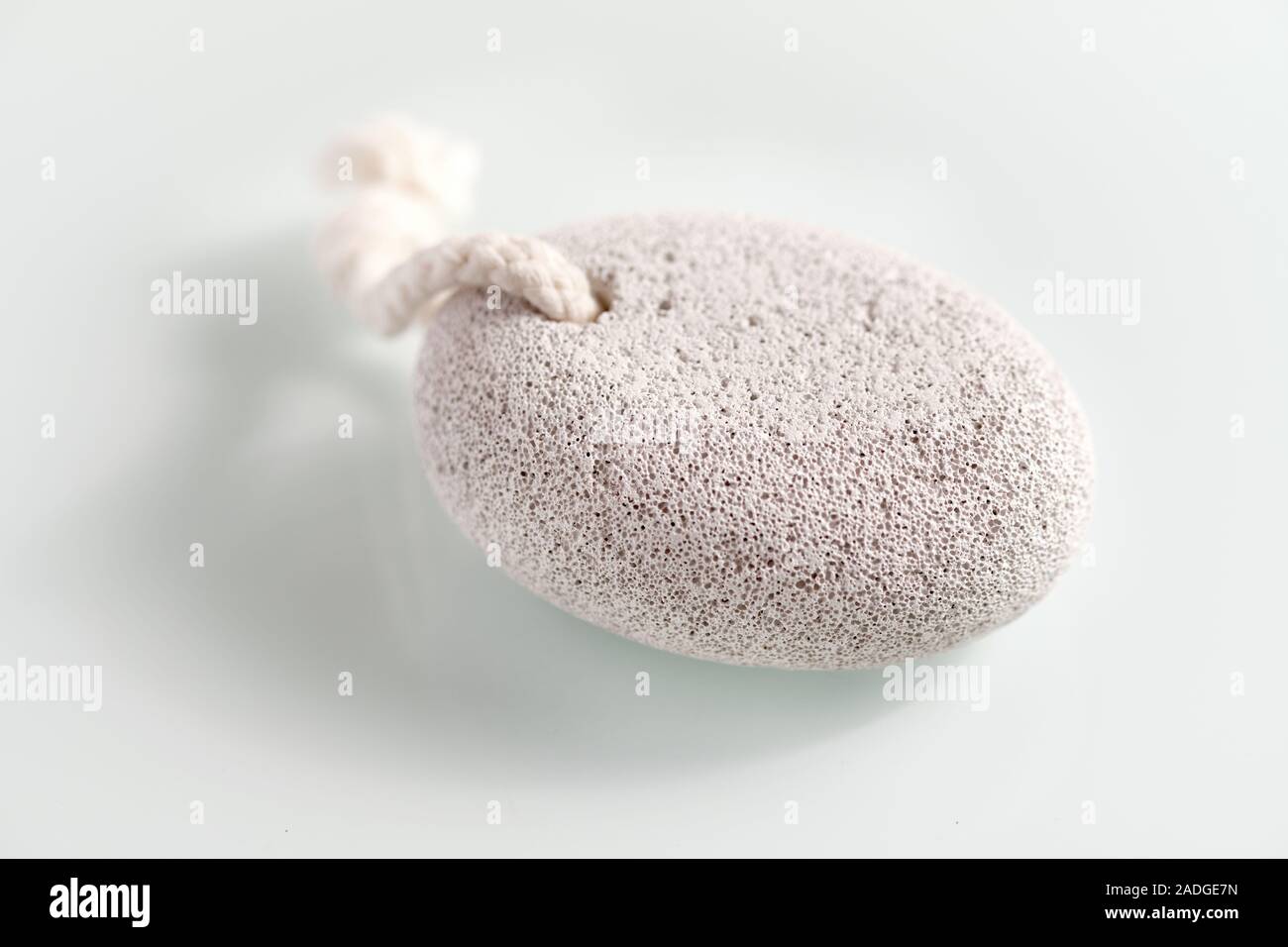White pumice stone with a cord lying on a white glass background Stock ...