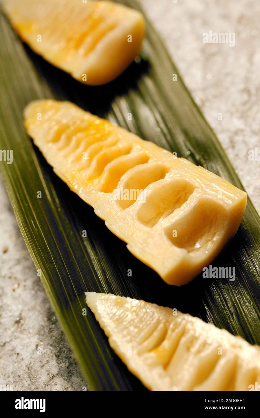 Bamboo shoots cut in half, lying on a bamboo leaf. These shoots are ...