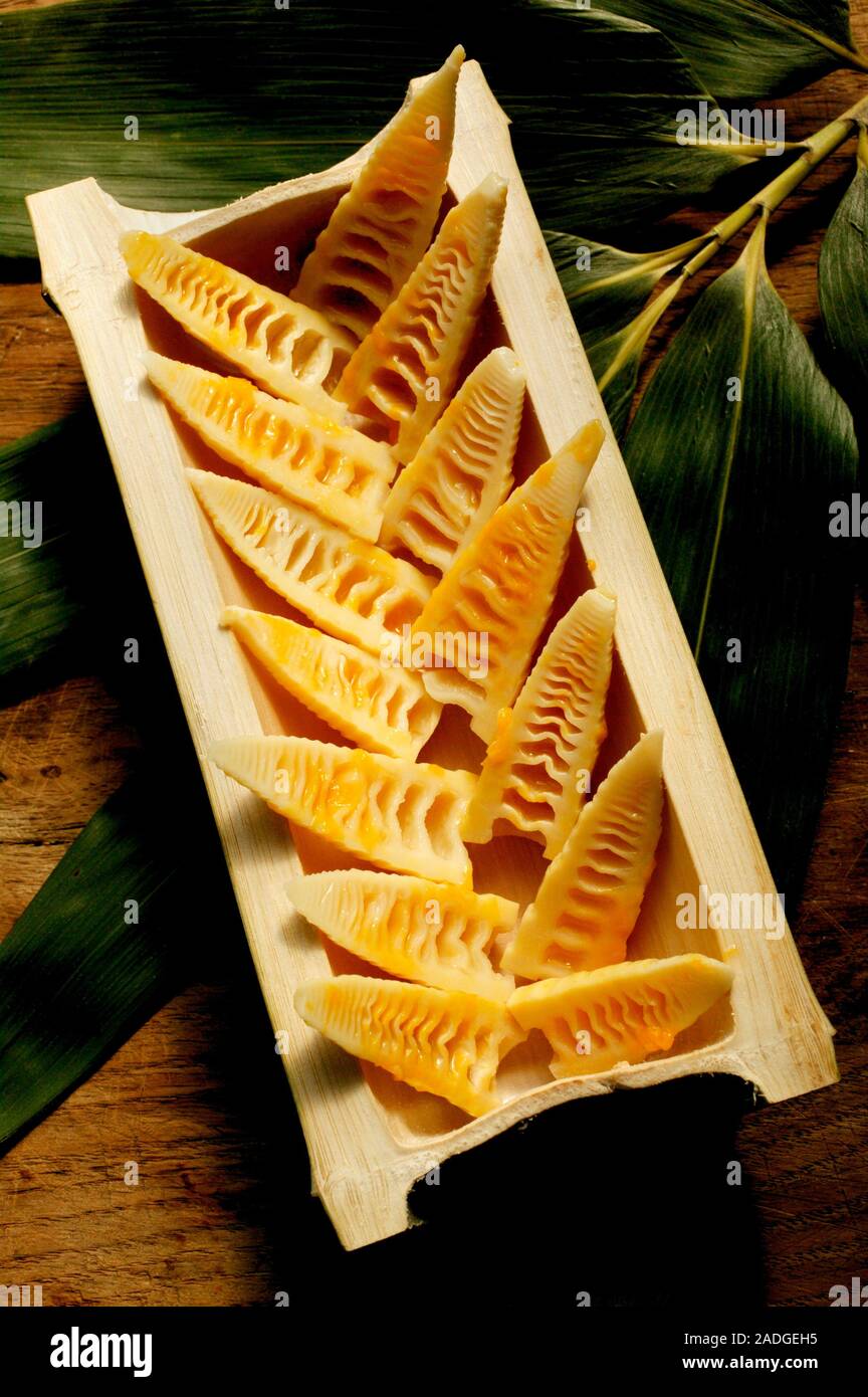 Bamboo shoots cut in half, lying in a container made from the adult ...