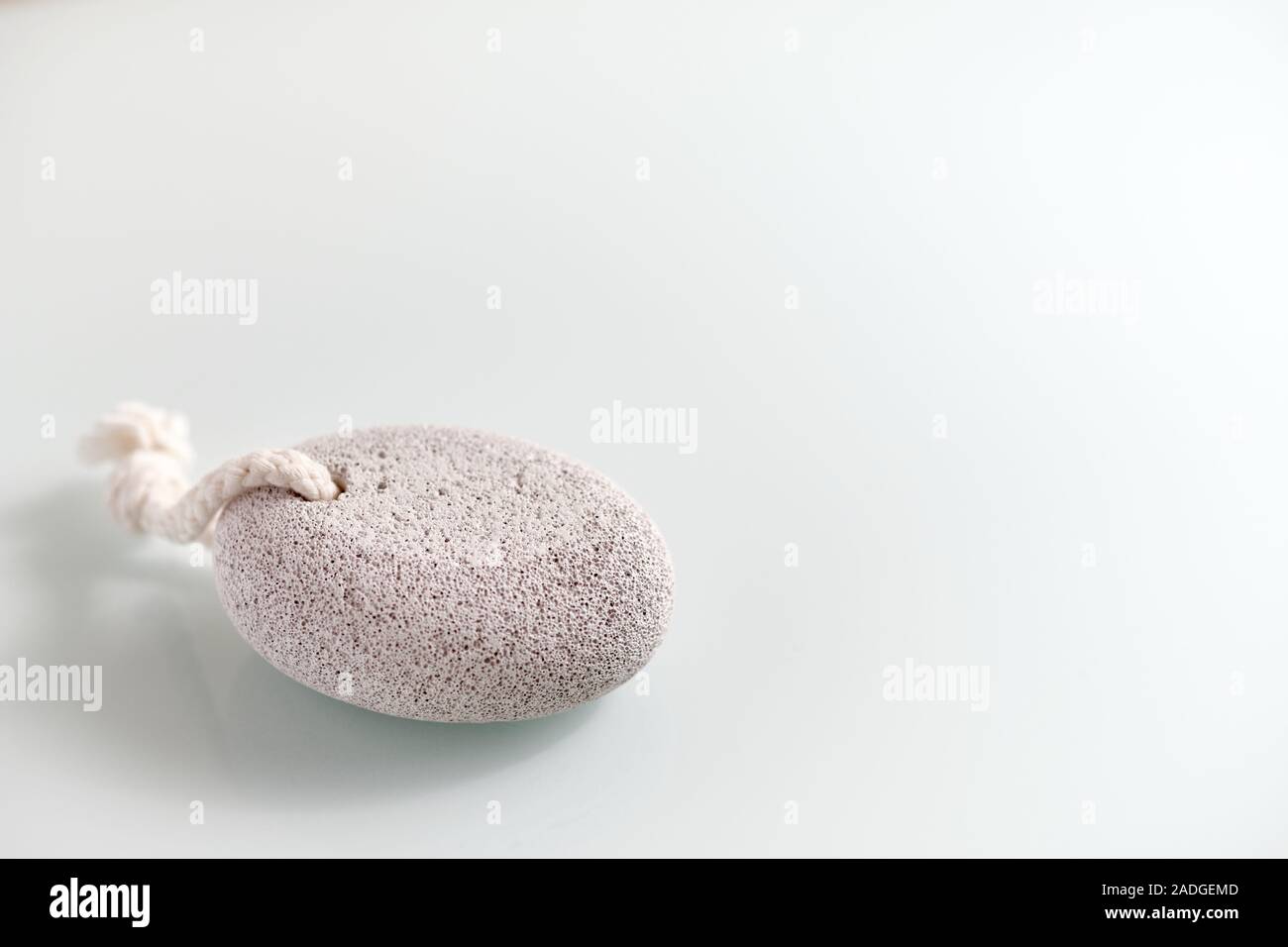White pumice stone with a cord lying on a white glass background Stock ...