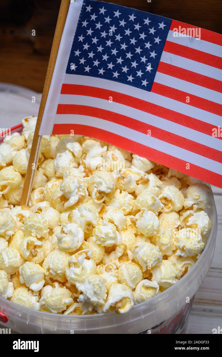Plastic bucket with tasty sweet popcorn ready to eat and flag of USA ...