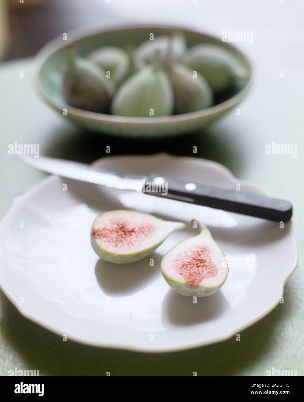Figs (Ficus carica). Fresh fig cut in half on a plate Stock Photo - Alamy