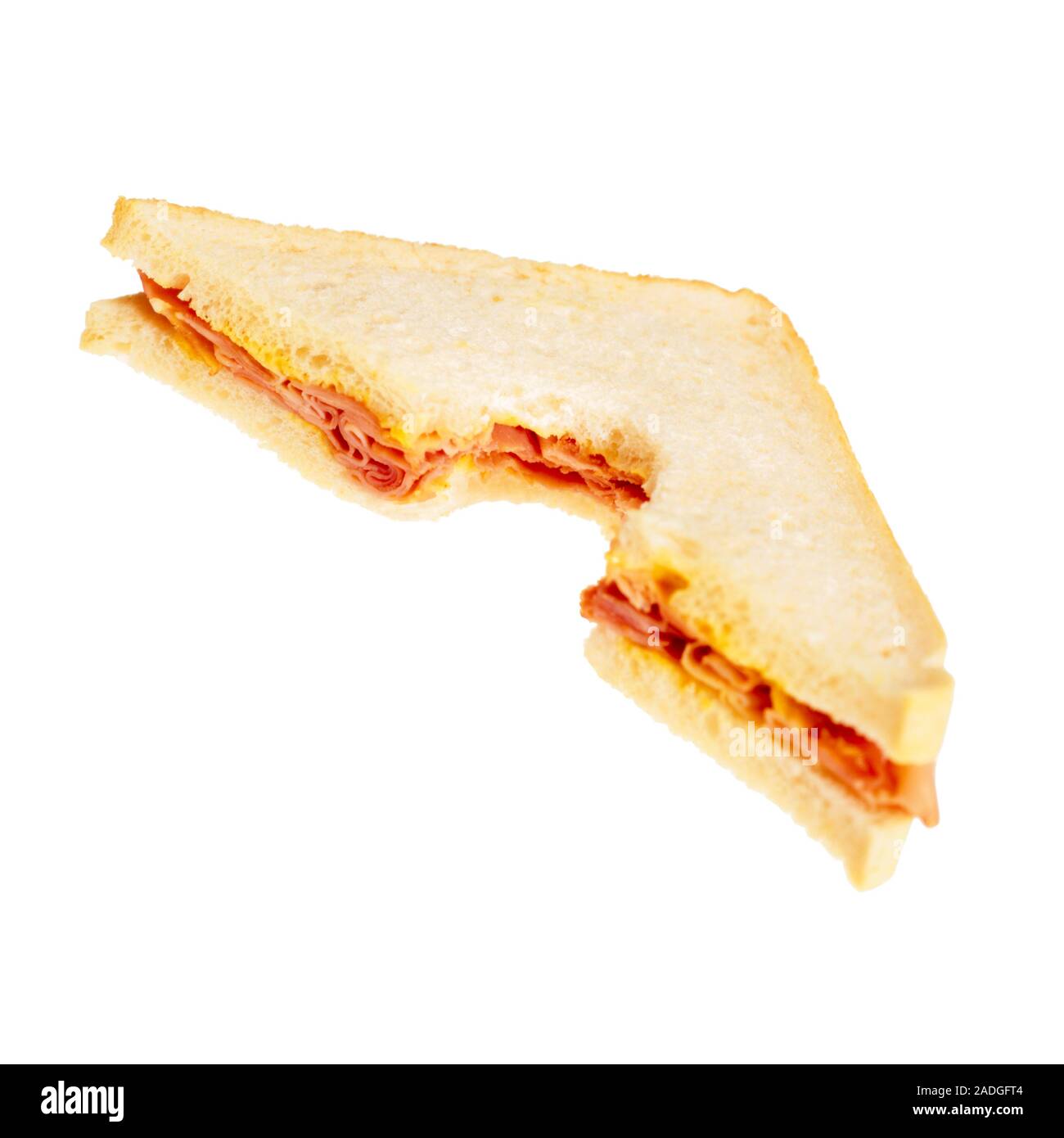Sandwich. Bite taken out of a white bread sandwich filled with ham and ...