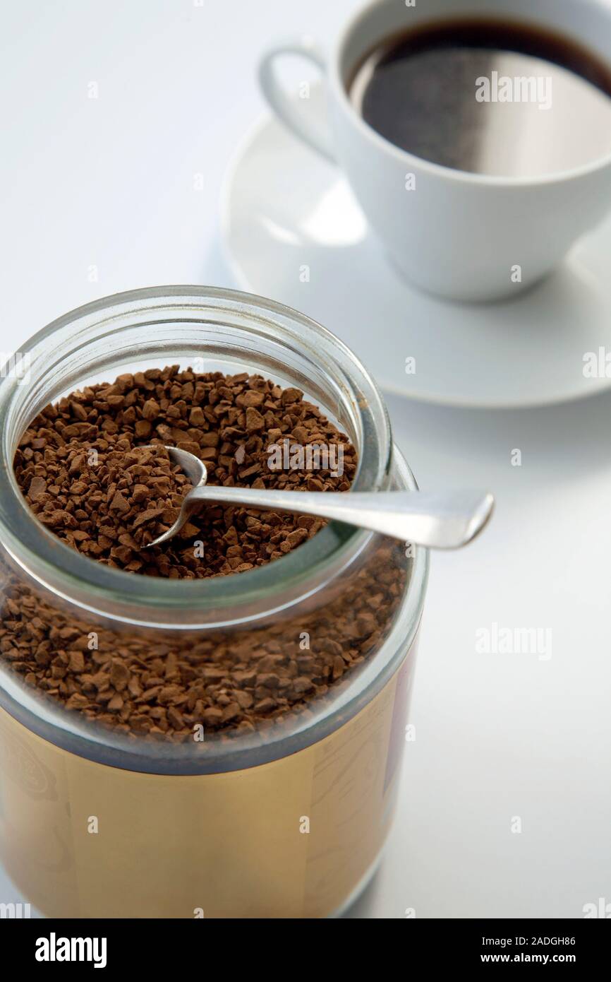 Instant coffee in a jar beside a cup of black coffee Stock Photo - Alamy