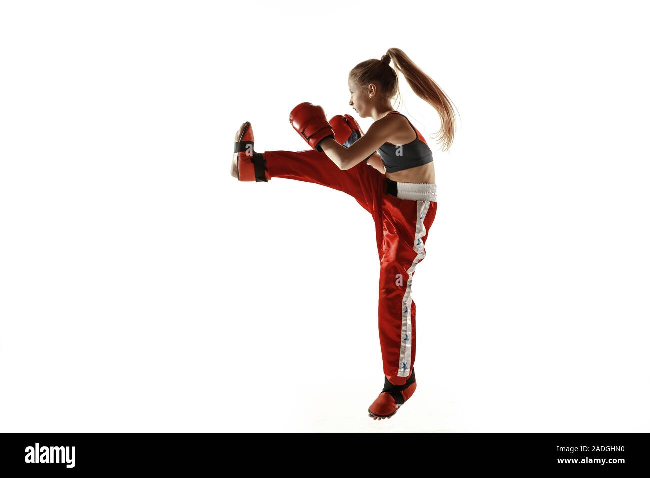 Young female kickboxing fighter training isolated on white background ...