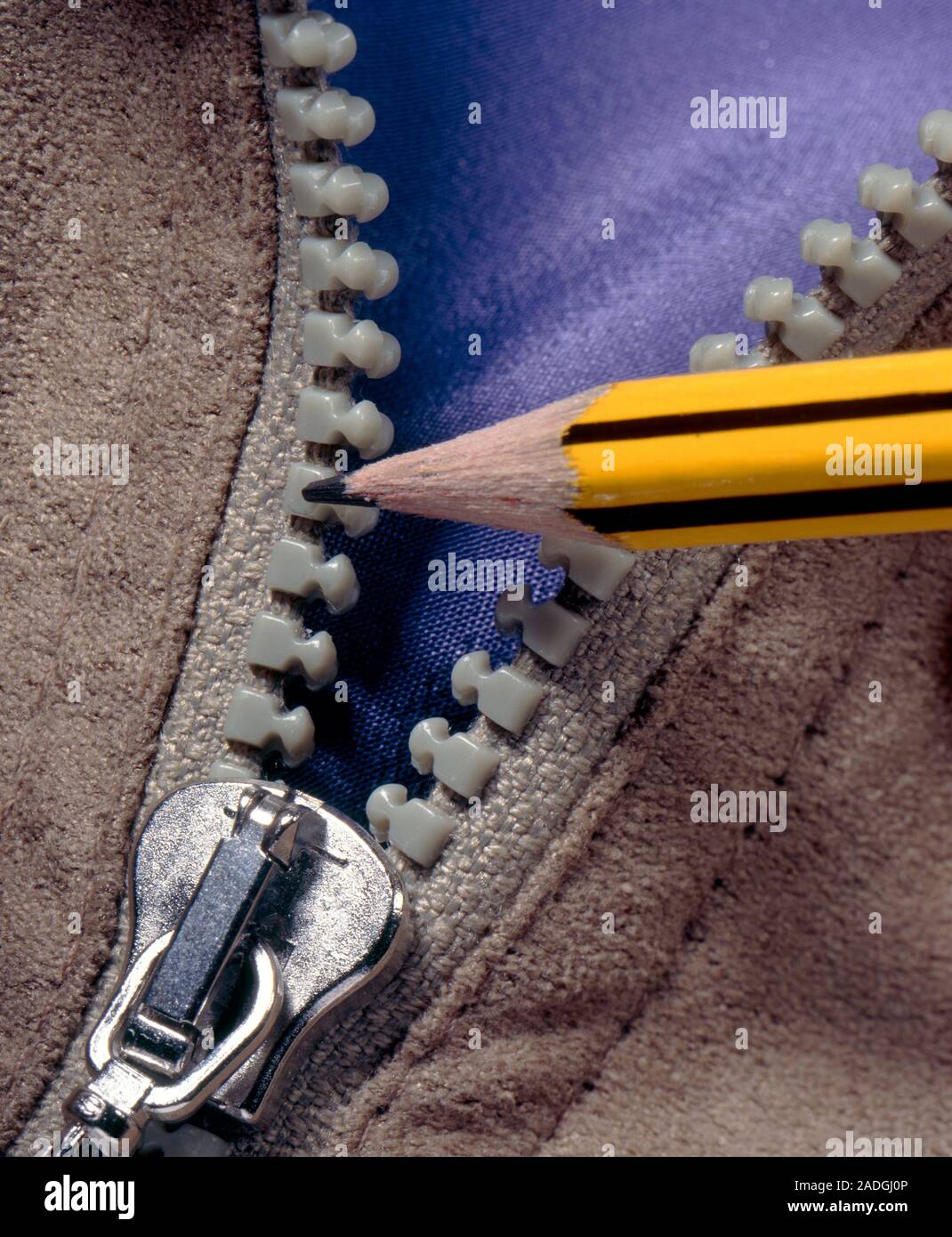 Zip fastener. View of a pencil being used to lubricate a zip fastener ...