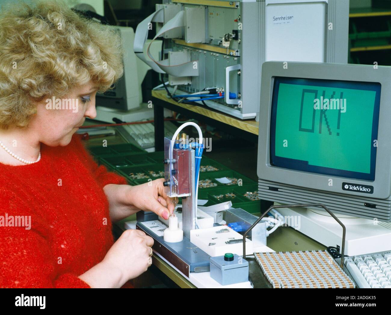 Headphone testing. Woman using a computer-aided device to test the ...