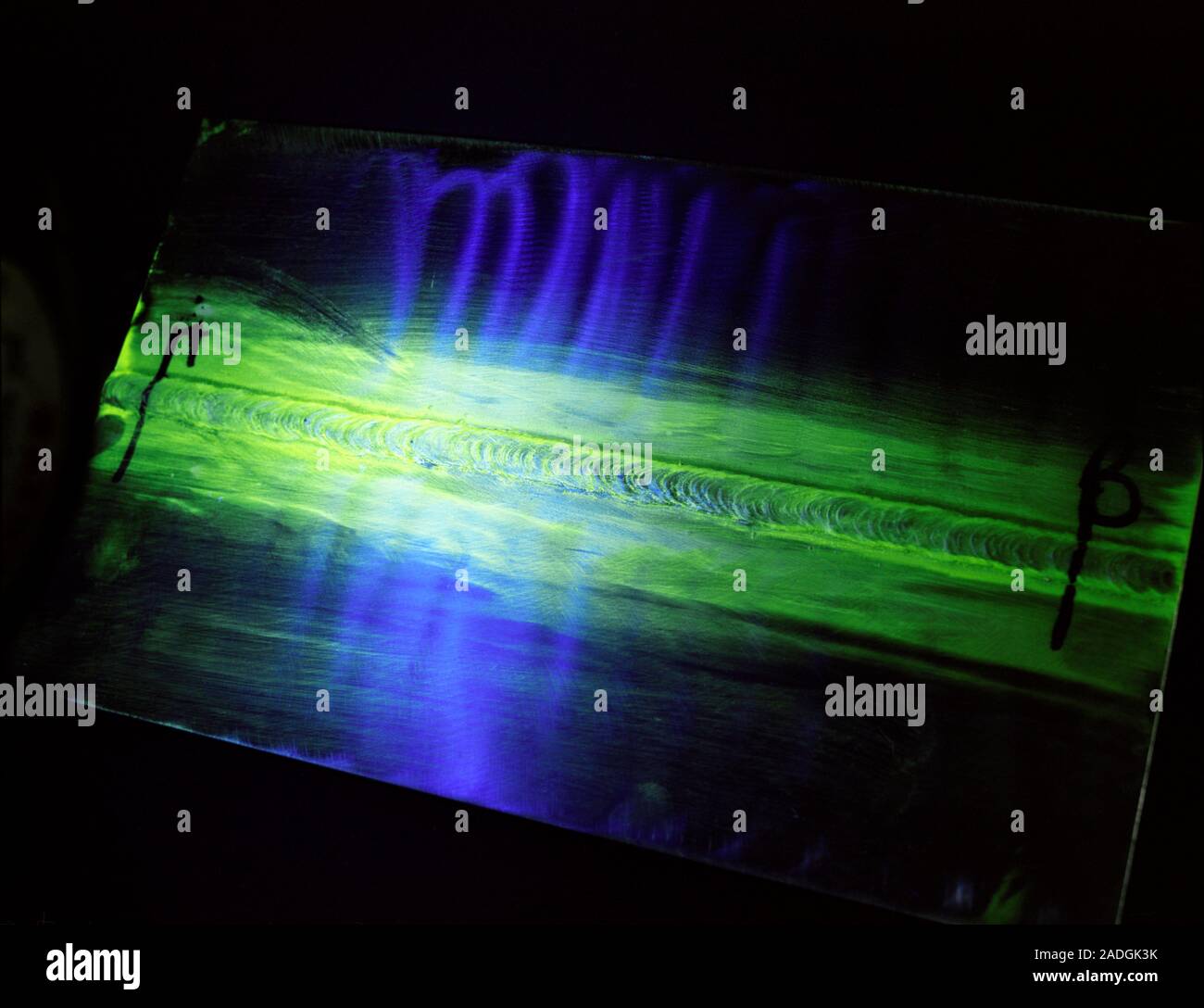 Fluorescent dye penetrant test on a metallic component, viewed under ...