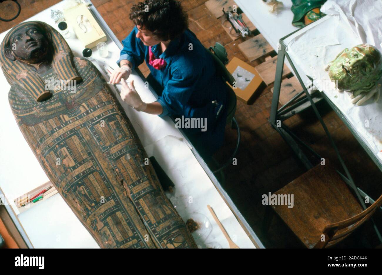 Restorer uses a syringe to inject an epoxy resin preservative into the ...