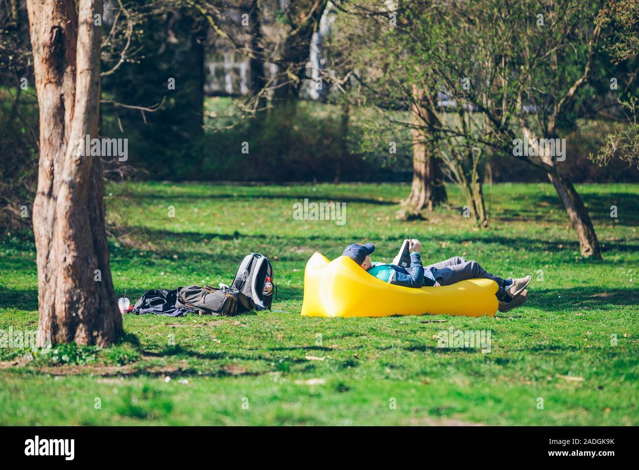 book reading concept. man in city park on inflatable mattress Stock ...