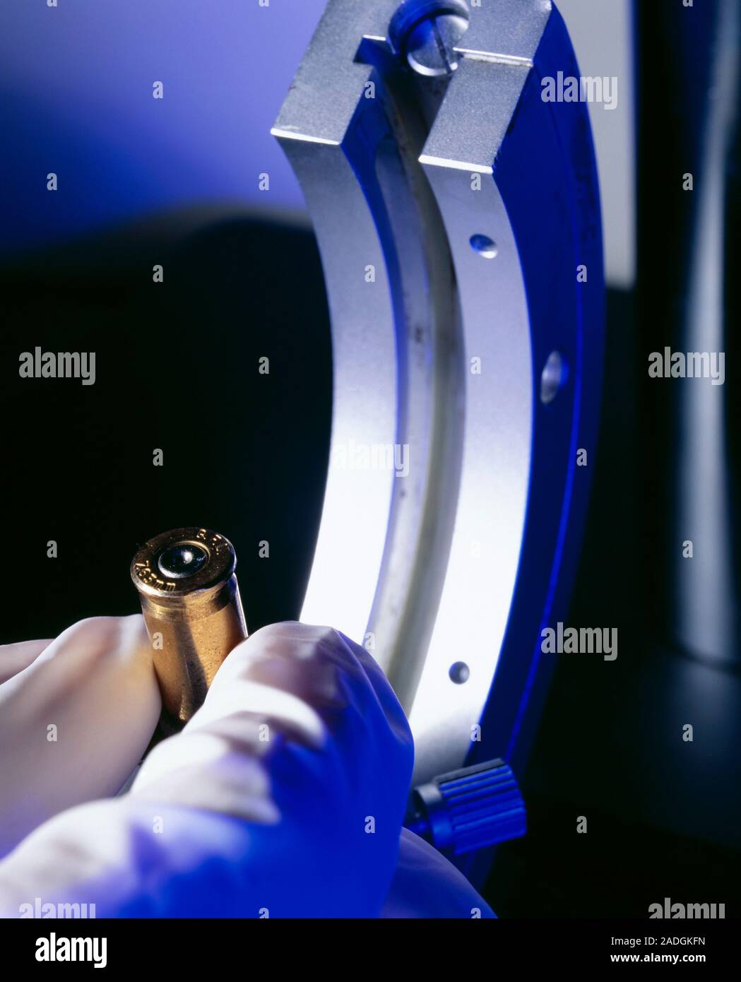 Used bullet cartridge examination. Cartridge shell being placed in a ...