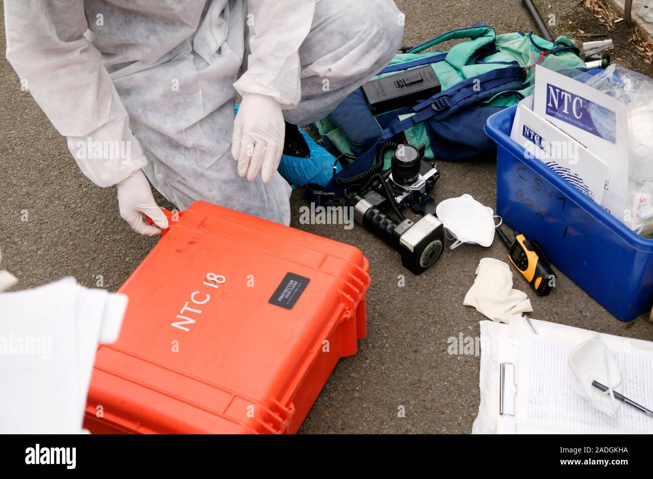 Forensic equipment. Scene of crime officer (SOCO) surrounded by ...