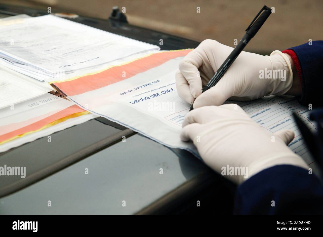 Collecting evidence. Scene of crime officer (SOCO) writing on the front ...