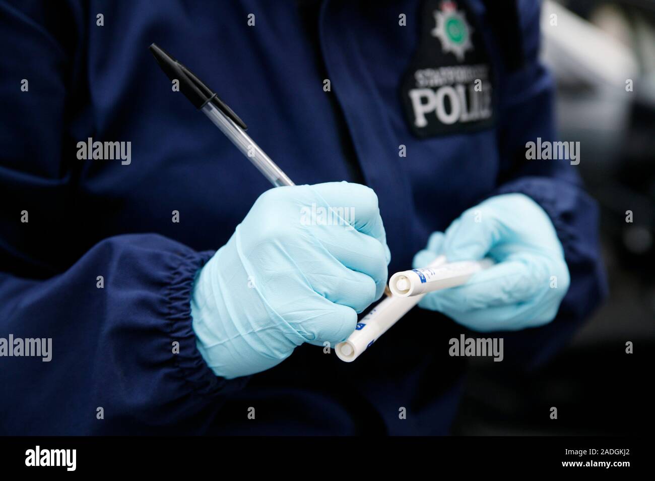Collecting evidence. Scene of crime officer (SOCO) writing on one of ...