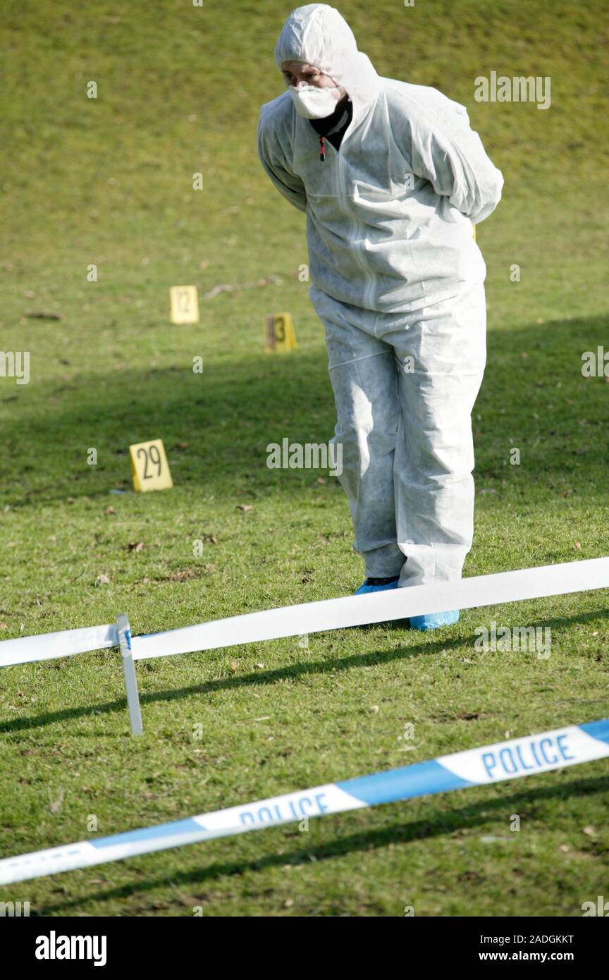 Forensics. Scene of crime officer (SOCO) standing near photo evidence ...