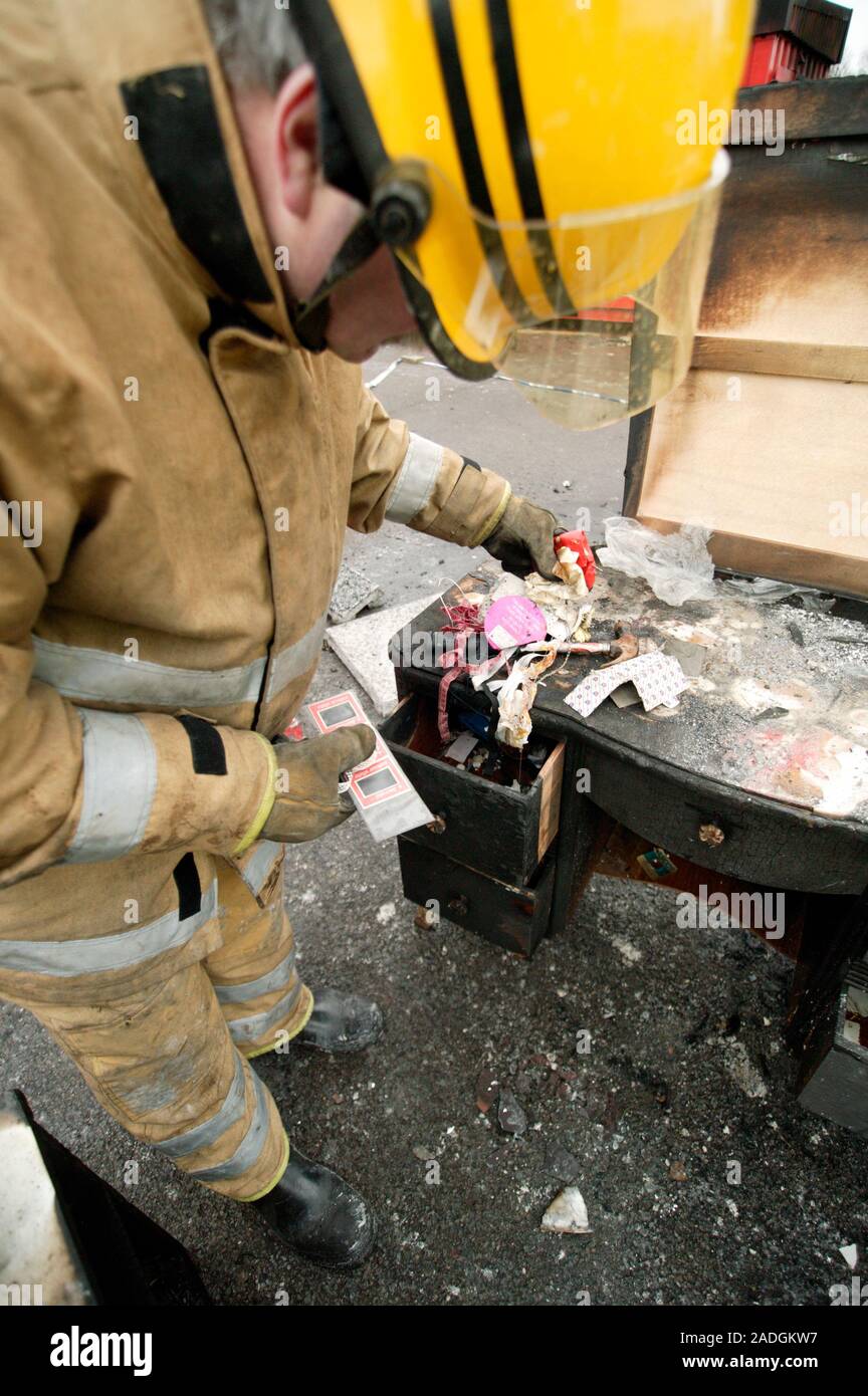 Firefighter examining evidence from a house fire. Evidence collected ...
