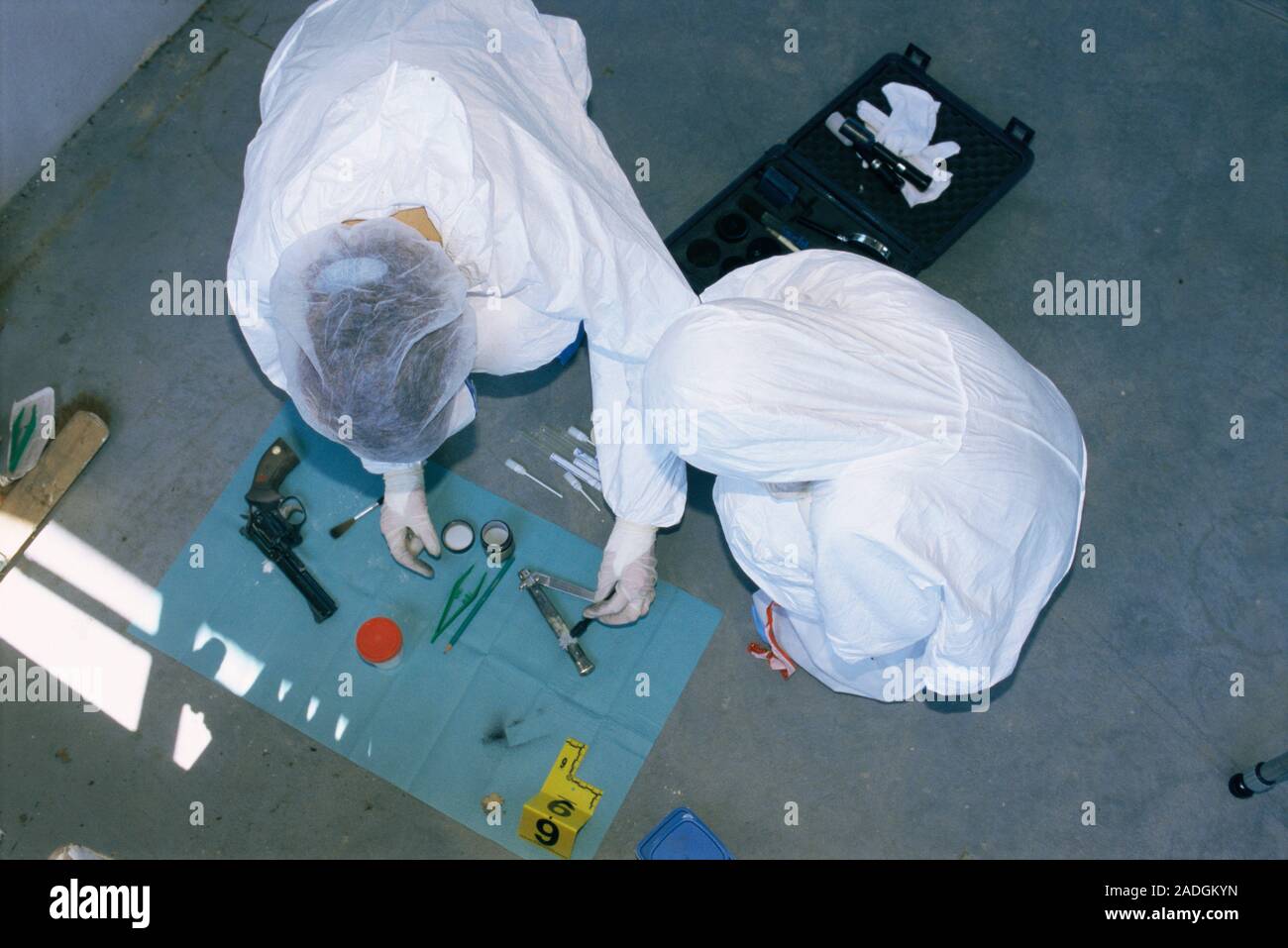 Forensics officers checking for fingerprints on a range of objects ...