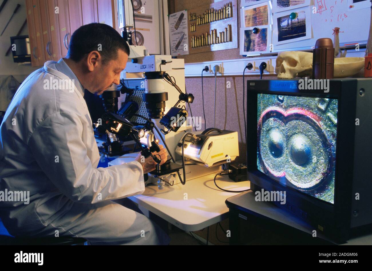 Forensic comparison of bullet casings. Forensic scientist using a ...