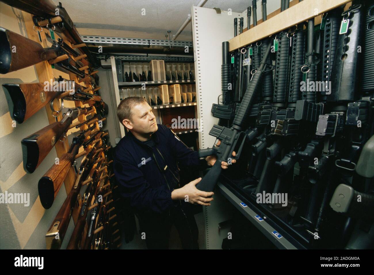 Police firearms collection. Policeman taking an automatic weapon from ...