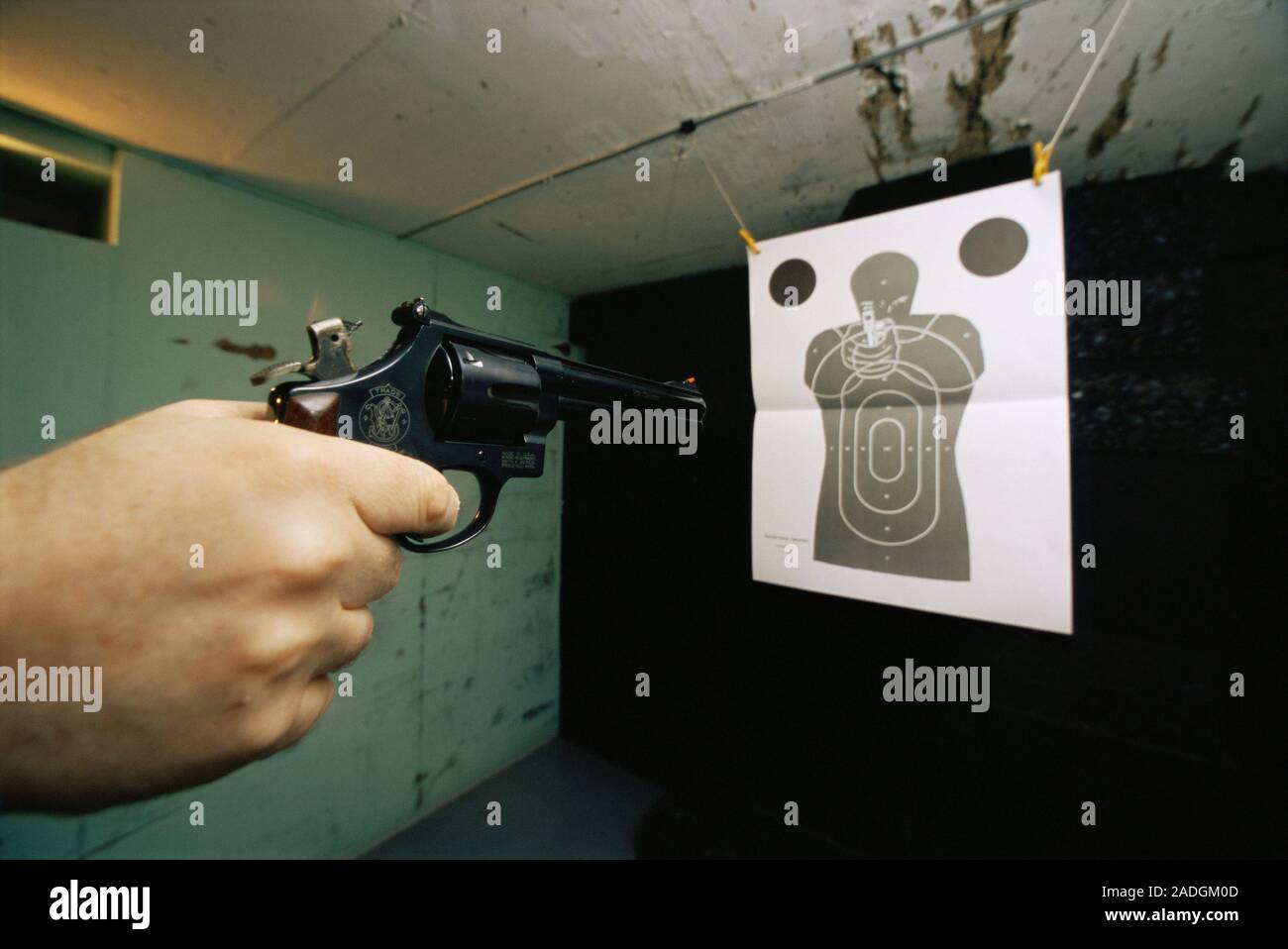 Forensic ballistics research. Policeman firing a pistol retrieved from ...
