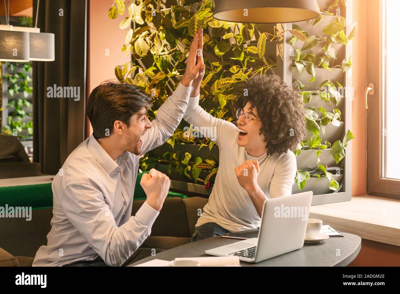 Young partners giving high five, enjoying business achievement Stock ...